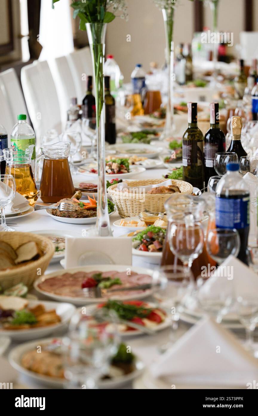 A long table is beautifully set for a formal event. A variety of dishes ...