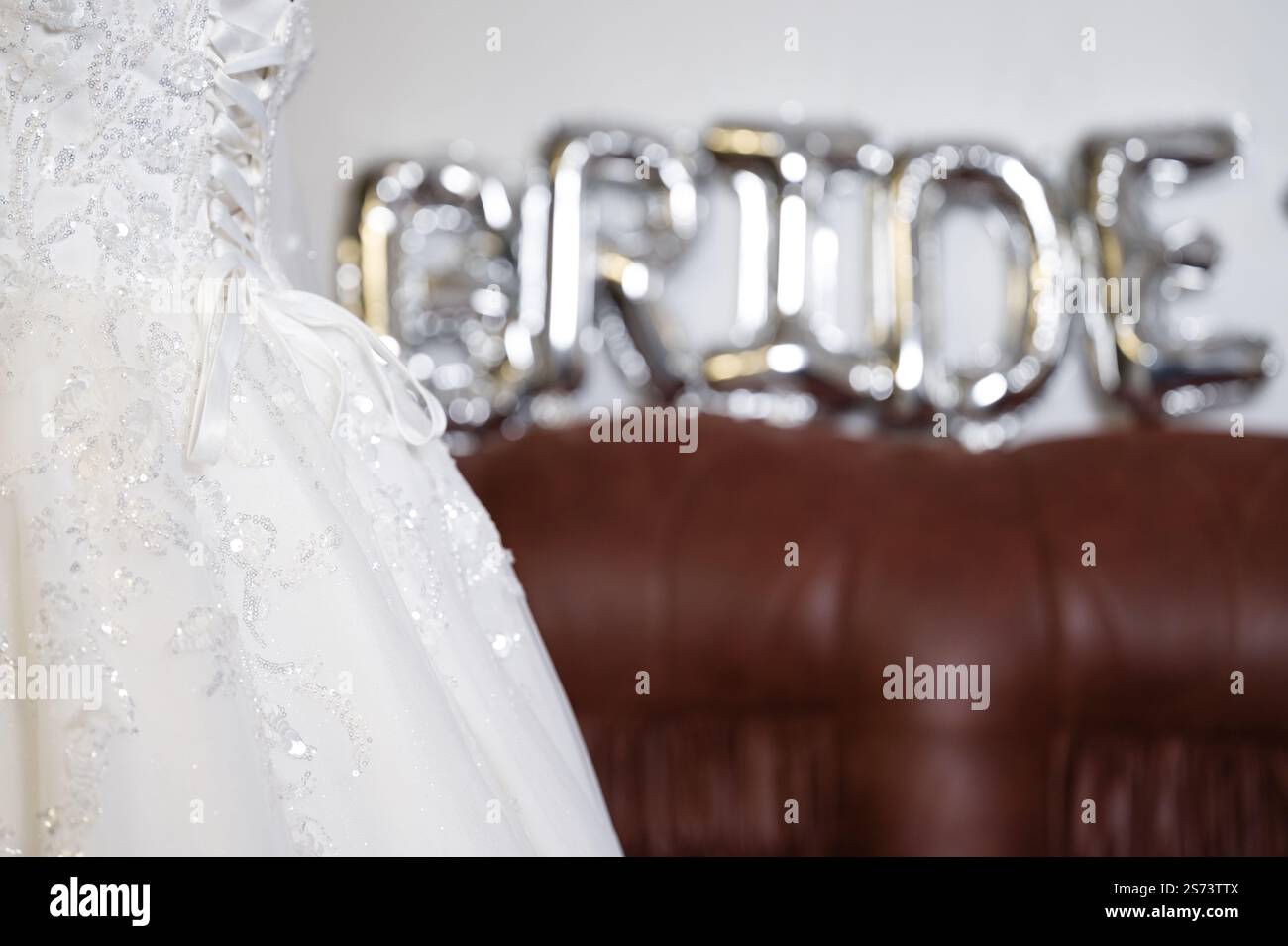 A close-up showcases a stunning white wedding gown adorned with ...
