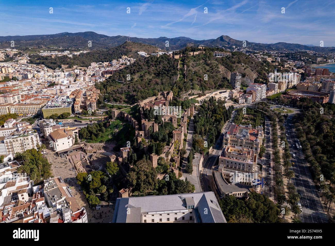 Aerial of La Alcazaba moorish castle on hill along lush gardens and ...