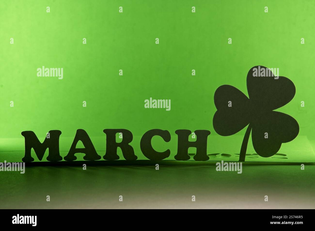 March month in silhouette against green with a shamrock Stock Photo - Alamy