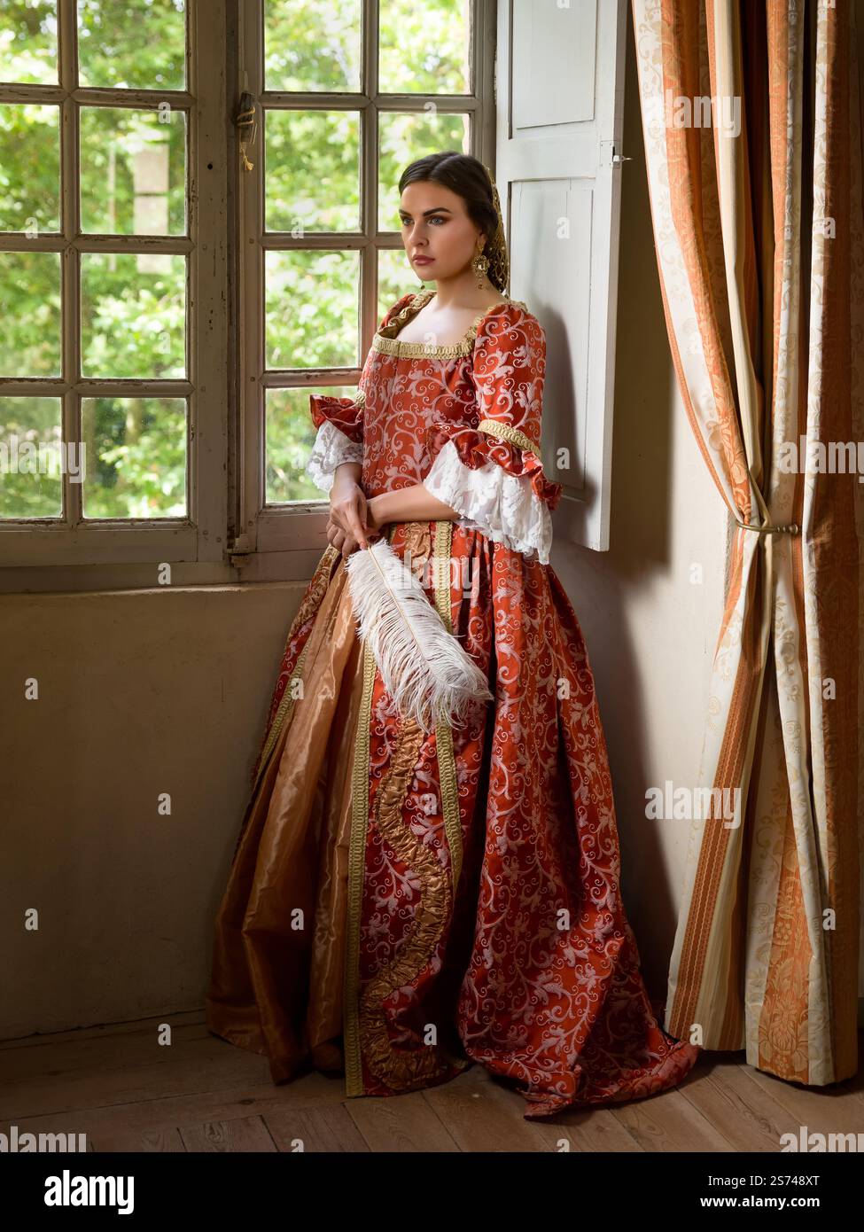 Woman wearing authentic Renaissance costome and headdress standing at ...