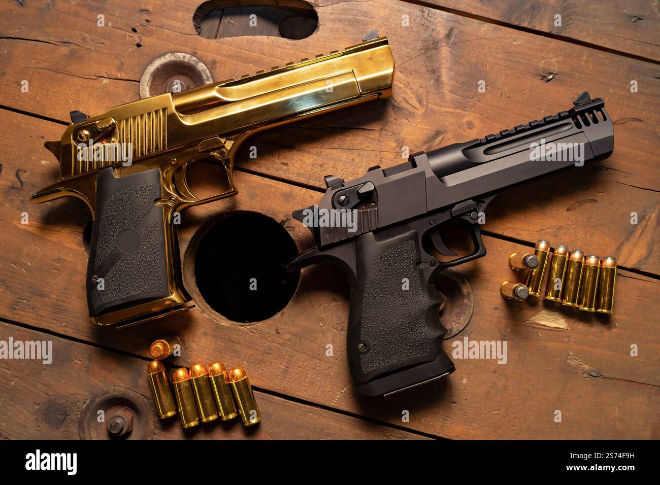 Cool powerful pistols in gold and titanium color on a wooden surface ...