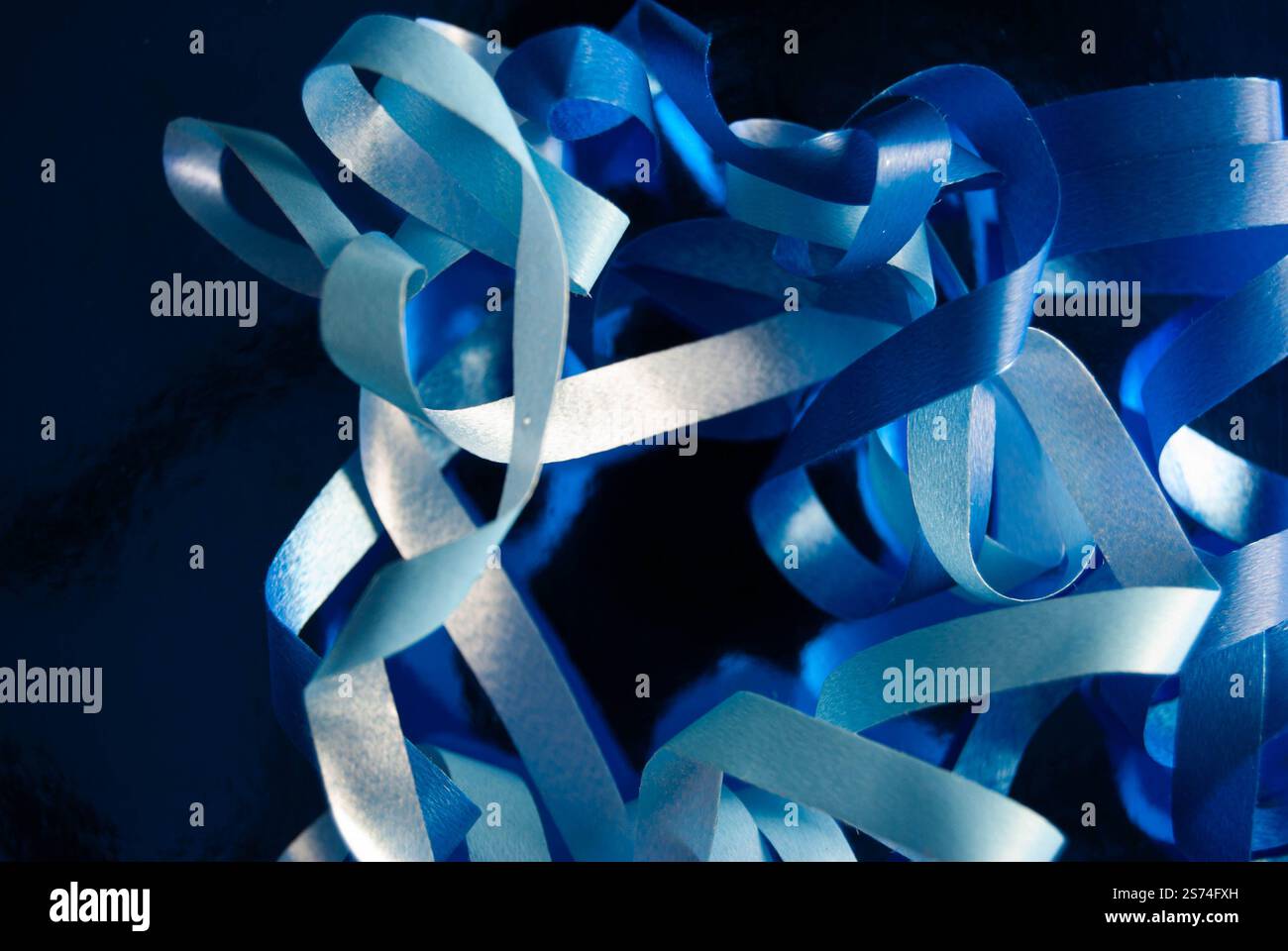 Elegant blue ribbons with a glossy finish, placed on a reflective ...