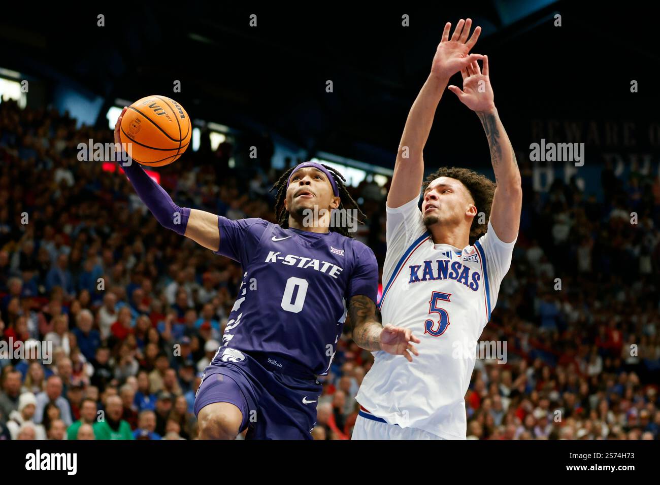 Kansas State guard Dug McDaniel (0) slips past Kansas guard Zeke Mayo ...