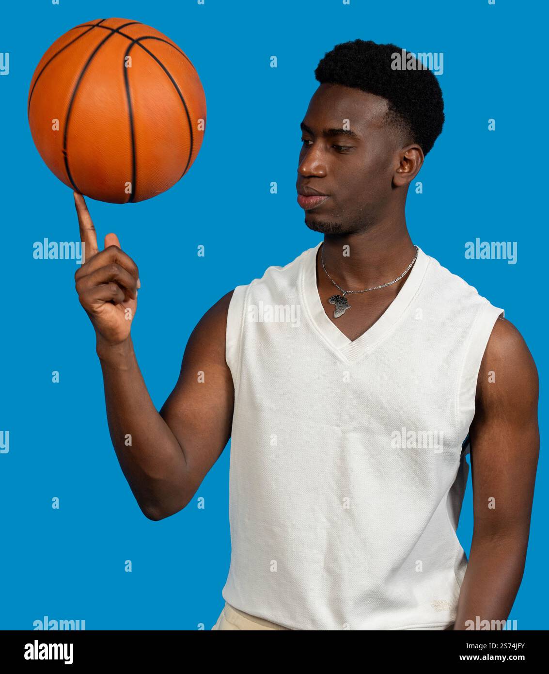 Stylish young man spinning basketball on fingertip, showcasing skill ...