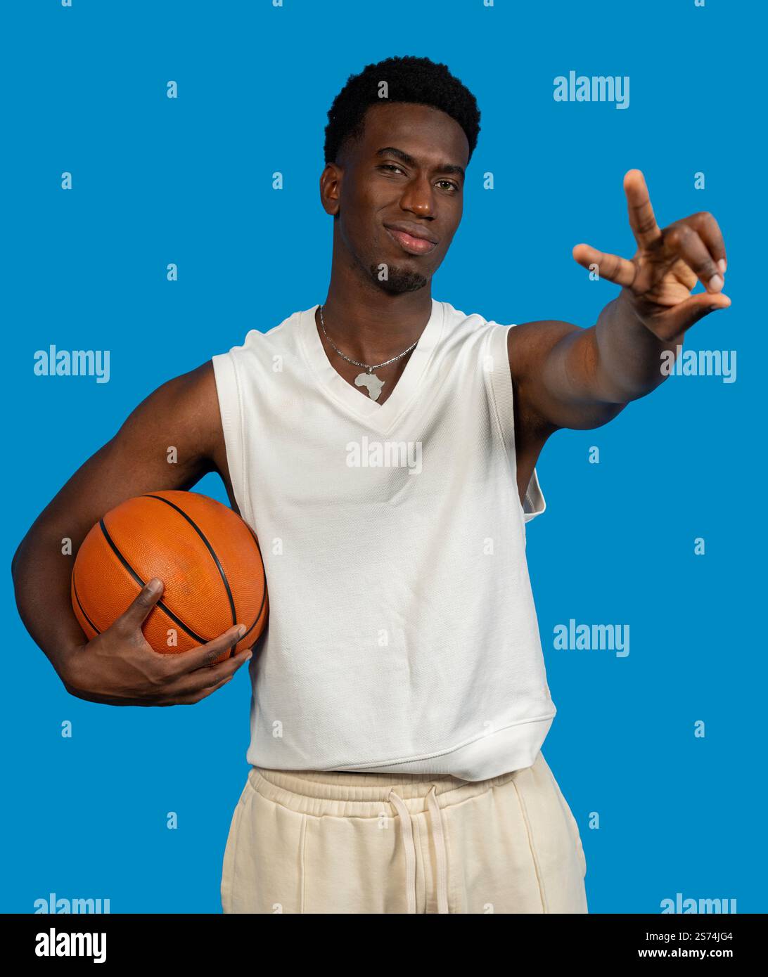 Young man basketball player holding a ball and showing three fingers on ...
