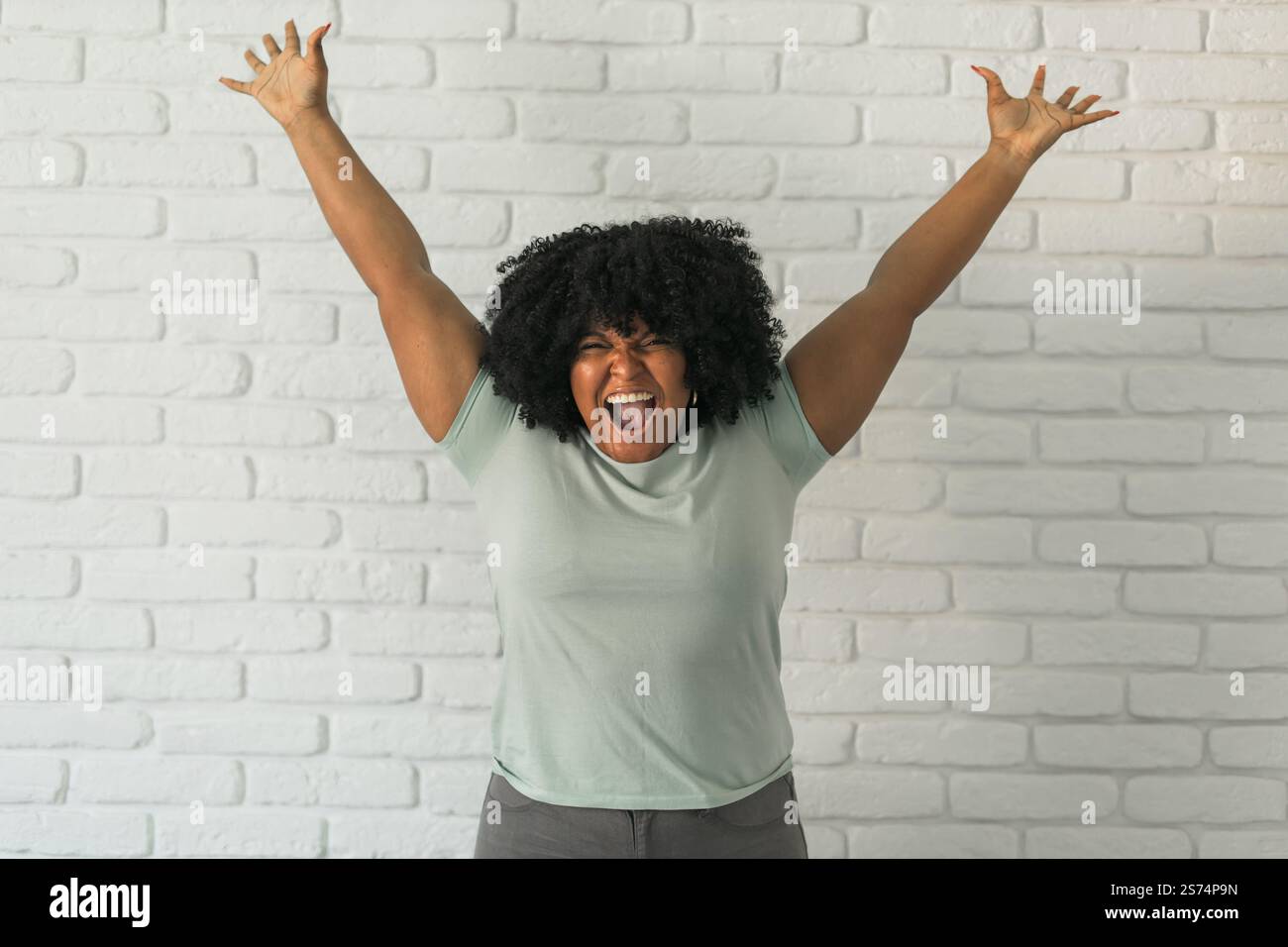 African American woman joyfully raises her hands up, a victorious ...