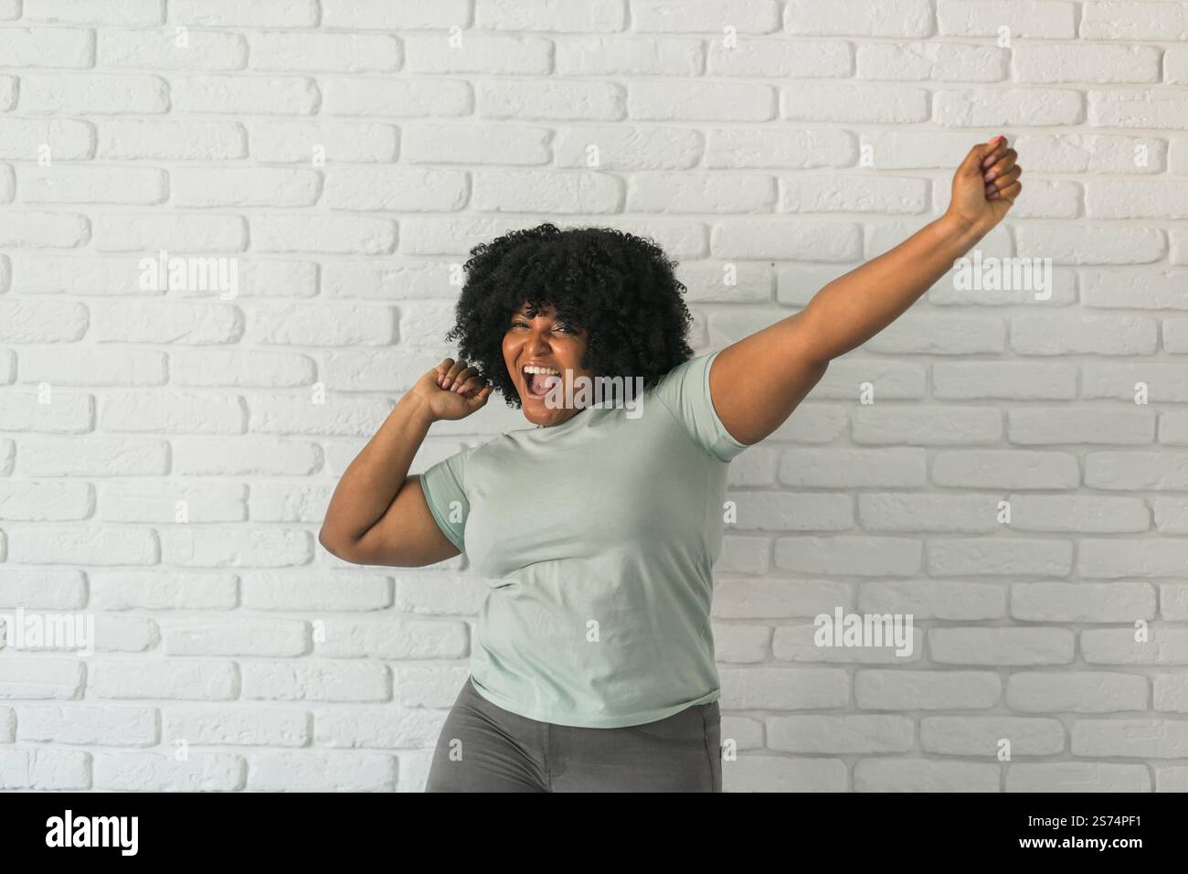 African American woman joyfully raises her hands up, a victorious ...