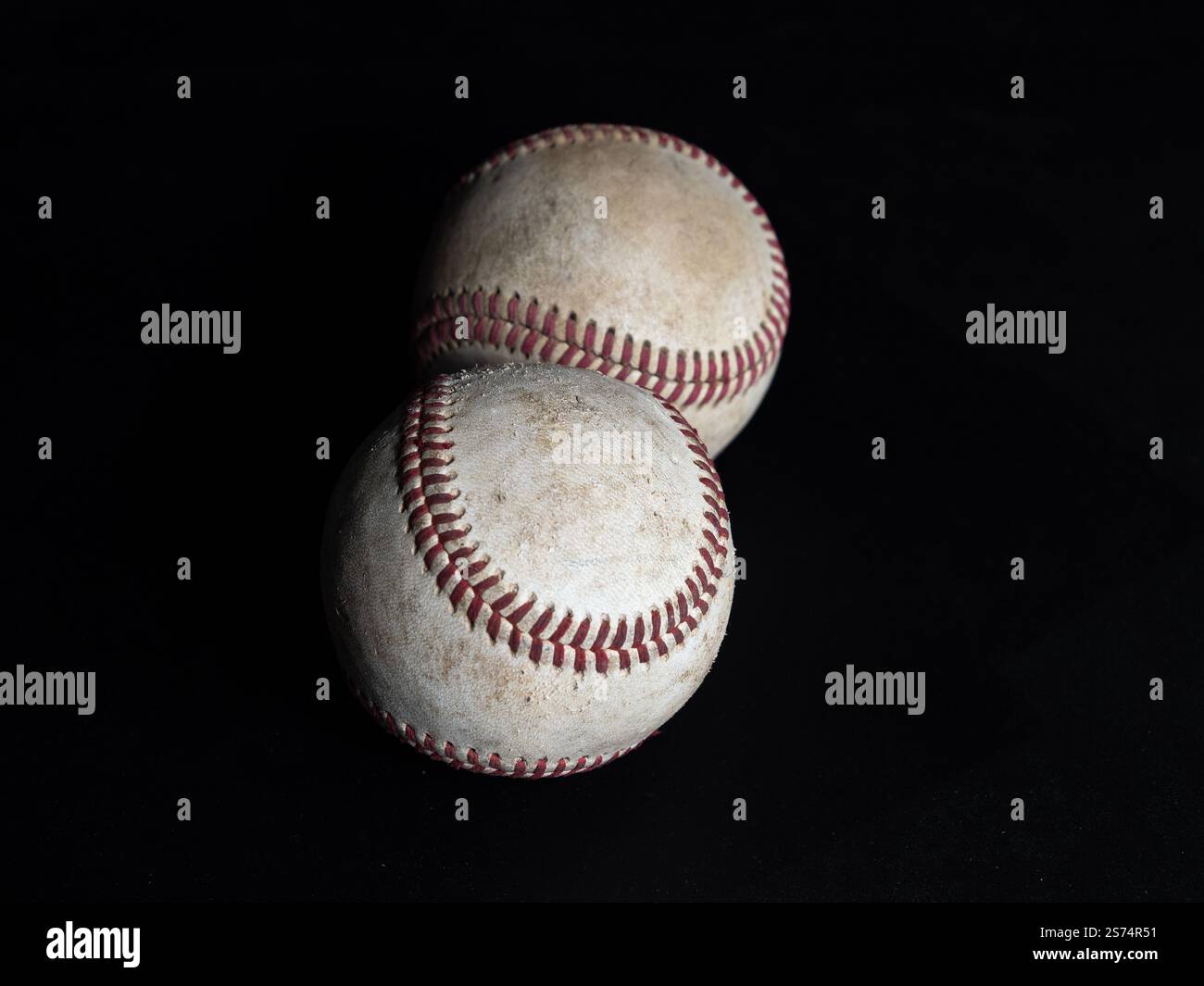 A minimalist composition featuring two baseballs viewed from above ...