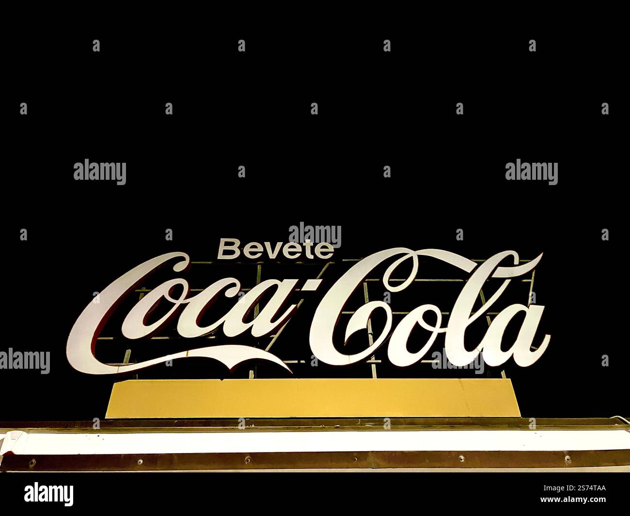 lluminated Coca-Cola sign reading "Bevete Coca-Cola" at night in ...