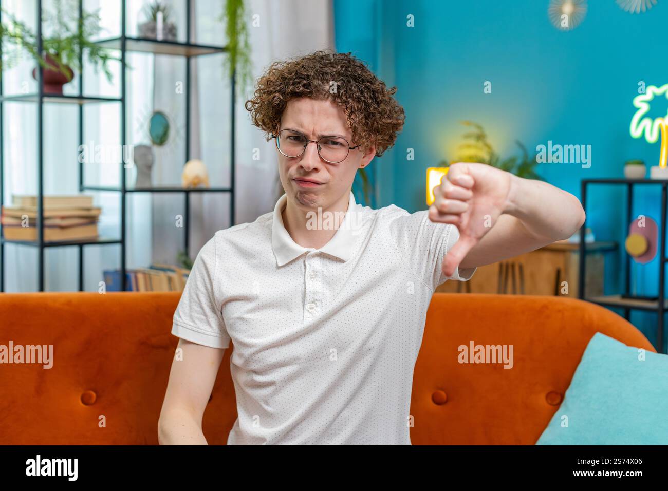 Dislike. Upset unhappy young Caucasian man showing thumbs down sign ...