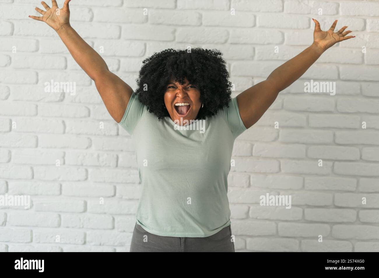 African American woman joyfully raises her hands up, a victorious ...