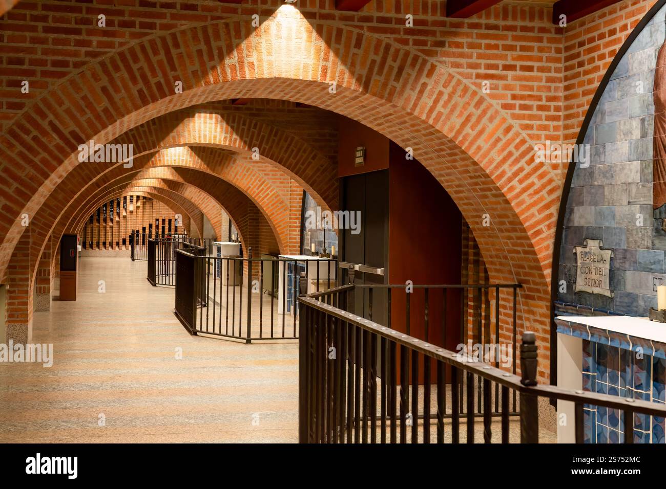 red brick romanesque archways with blue reservoir water beyond ...