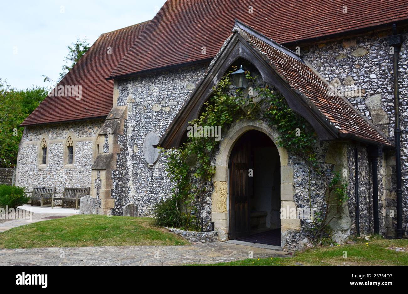Entrance of the St. Simon and St. Jude Church covered in ivy. East Dean ...