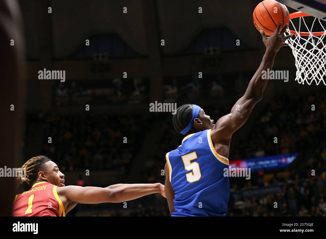West Virginia guard Toby Okani (5) makes a layup while being guarded by ...