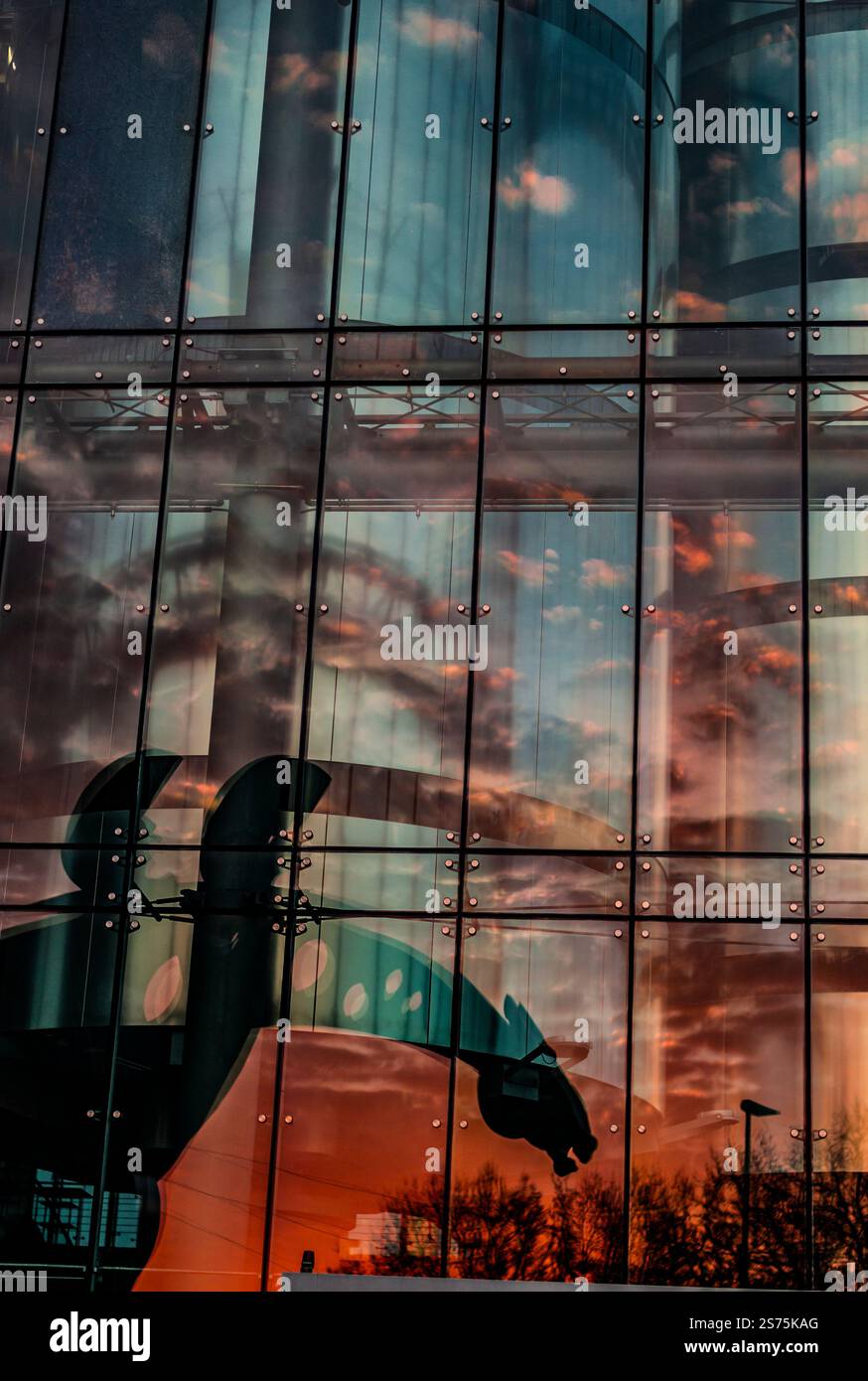 Glass facade reflecting sunset hues, merging architecture, light, and ...