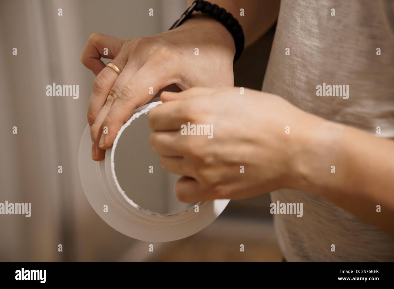 Close-Up of Hands Demonstrating a Crafting Technique with Tape Roll ...