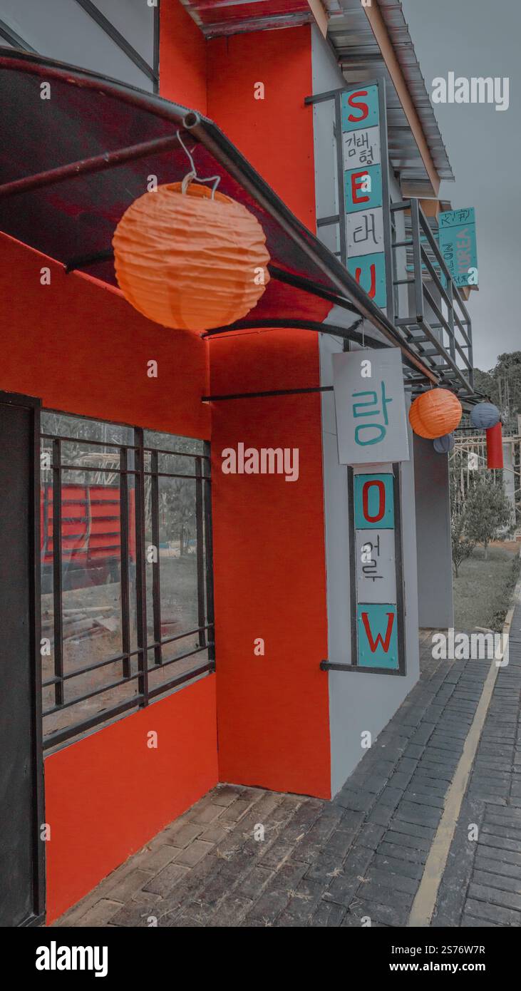 A vibrant orange and gray building exterior with hanging lanterns and ...