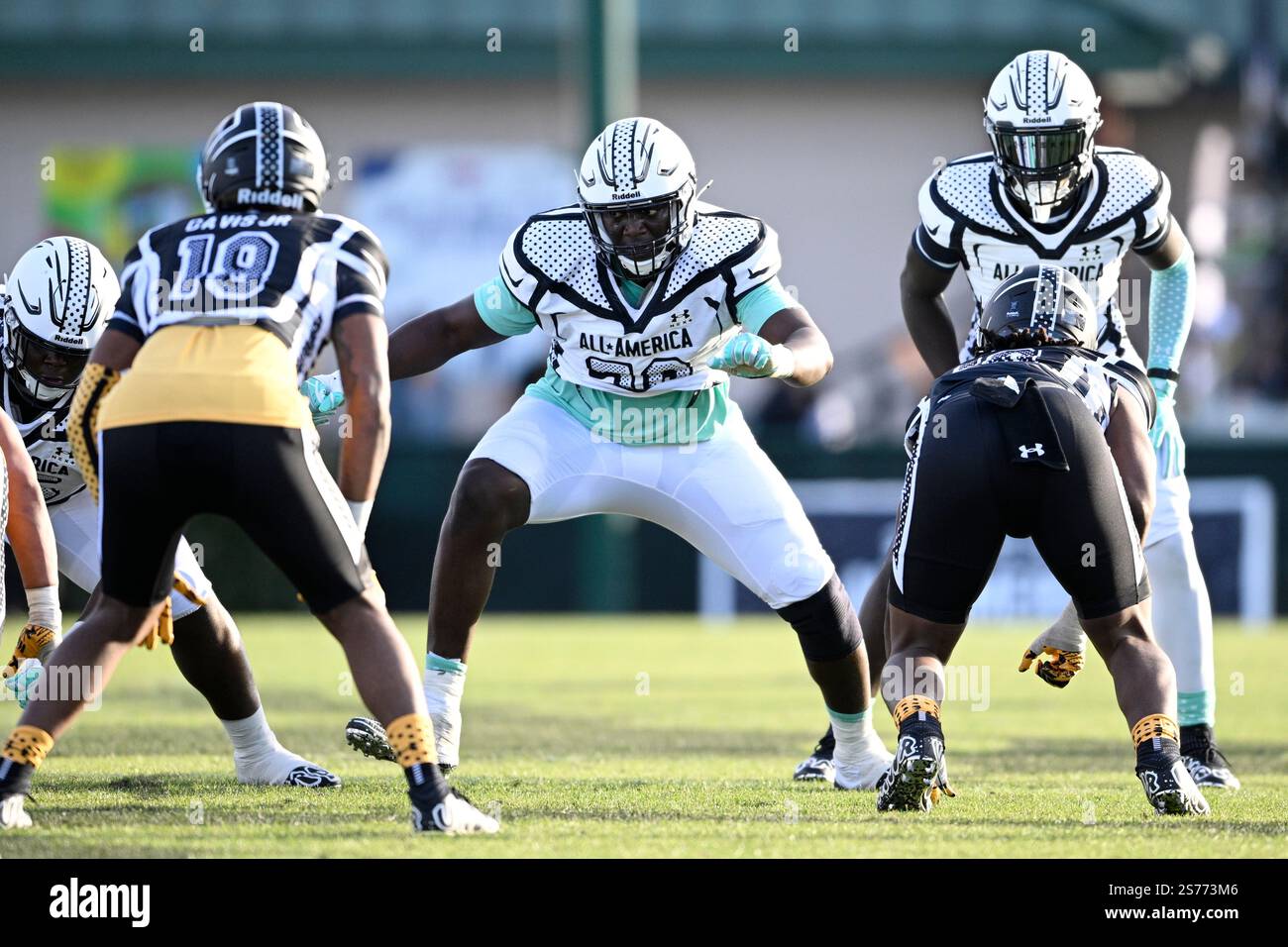 Team Unstoppable offensive lineman Michael Fasusi, center, sets up to ...