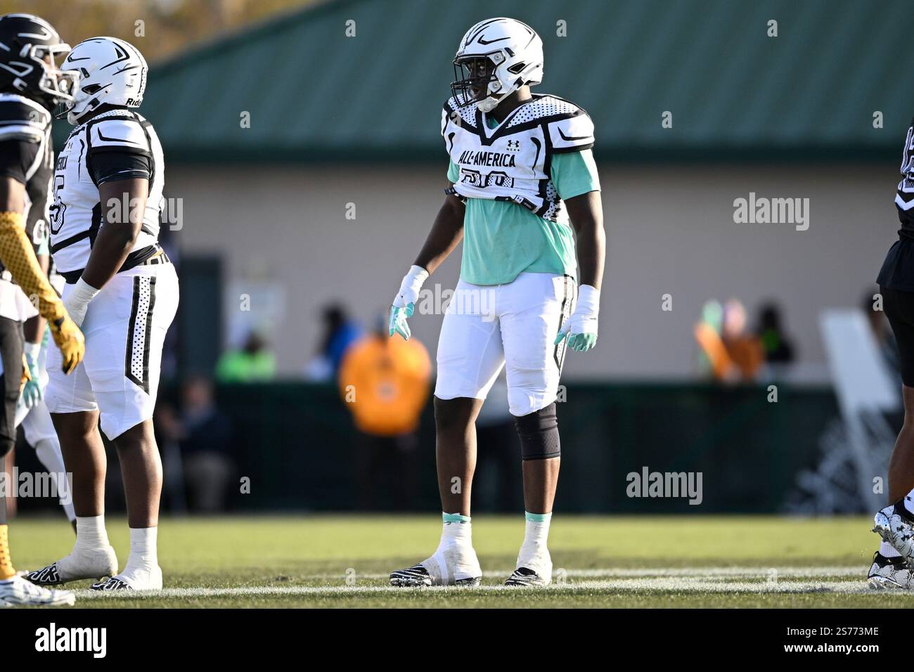 Team Unstoppable offensive lineman Michael Fasusi, center, sets up for ...