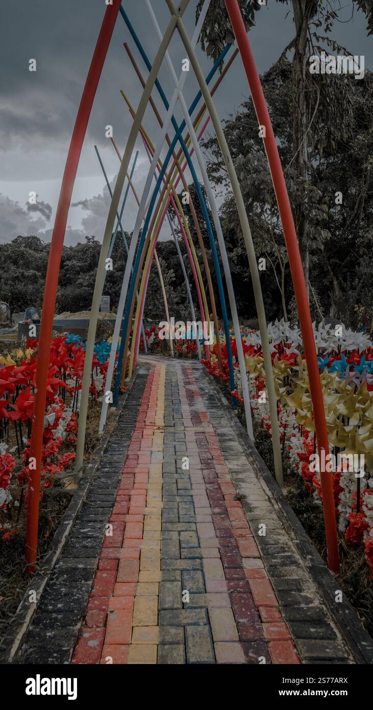 Colorful pathway with rainbow bricks and arching poles in a garden ...
