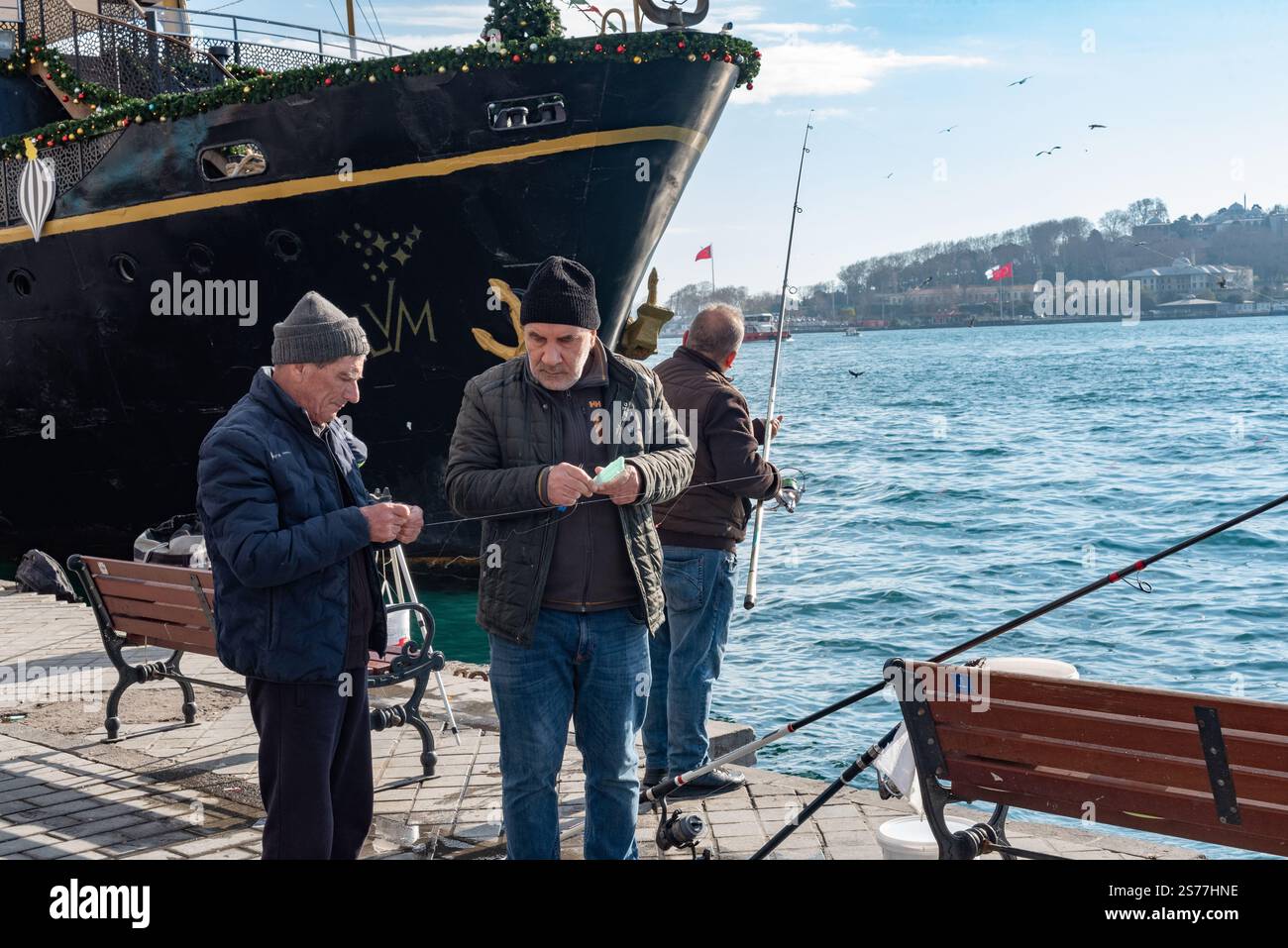 Turkish men fishing on the dock at Karakoy Port on the European Shore ...