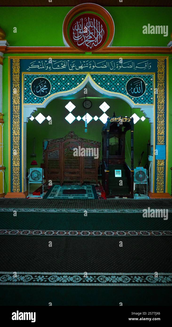Interior view of a mosque featuring intricate green walls, decorative ...