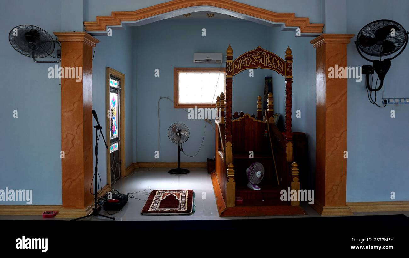 Interior of a mosque featuring a prayer area with a wooden pulpit ...