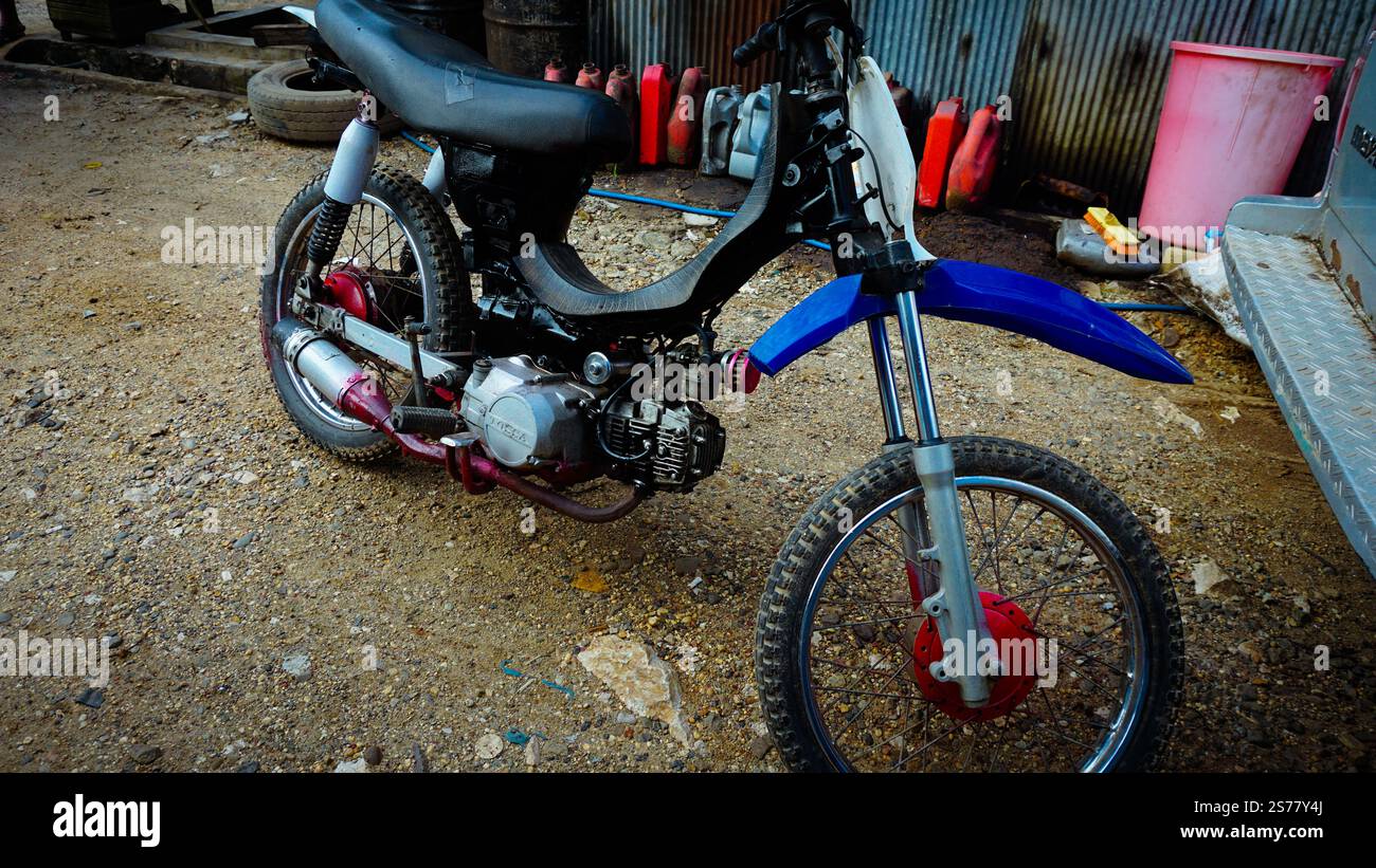 A modified dirt bike with a blue front fender and a unique exhaust ...