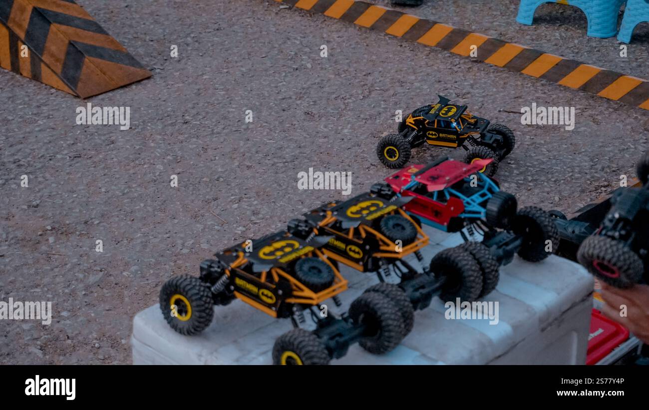 A scene featuring remote-controlled cars on a dirt track. Various ...