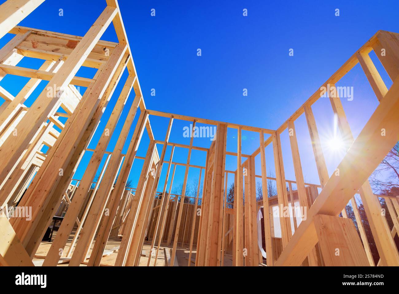 Beams constructing new building as wooden frames rise against bright ...