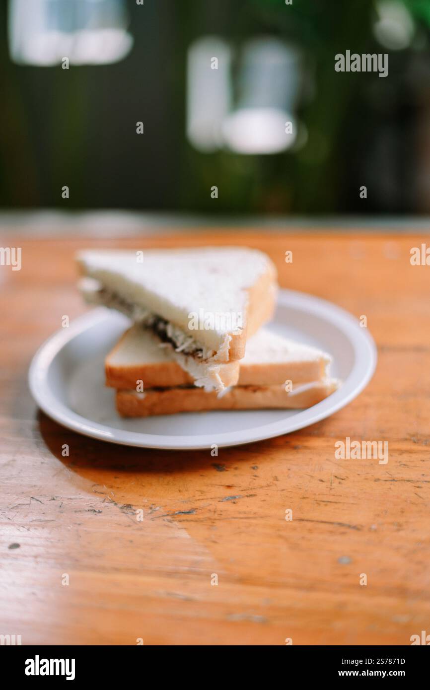 A hand offers a plate with a delicious chocolate crunch sandwich Stock ...