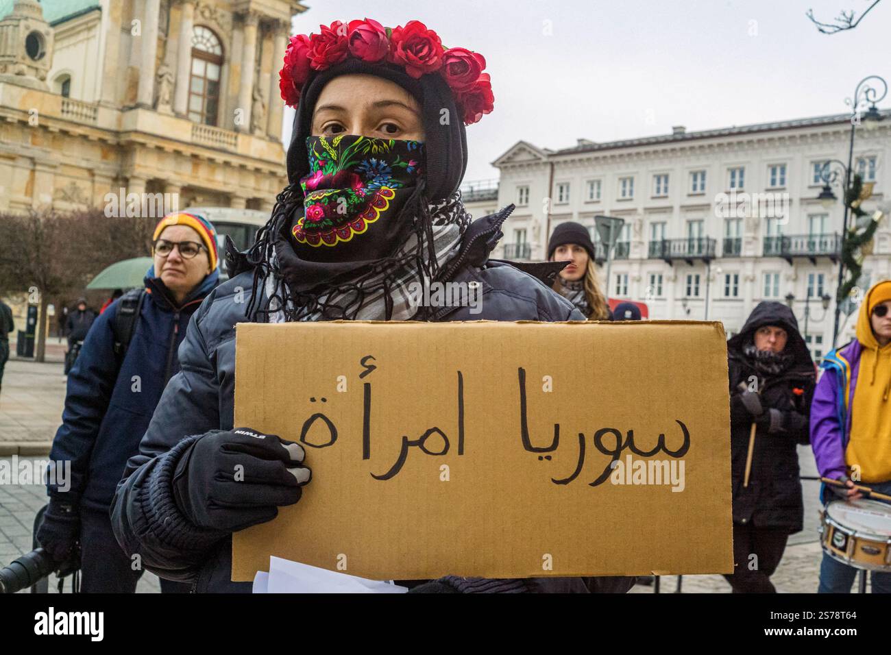 A protestor holds a banner that says, in Arabic, "Syria is a woman". In ...