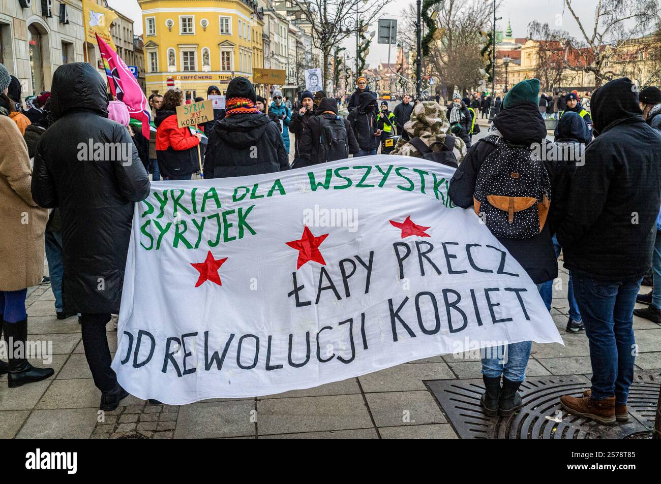 Protestors hold a banner that says, in Polish, "Syria for all Syrians ...