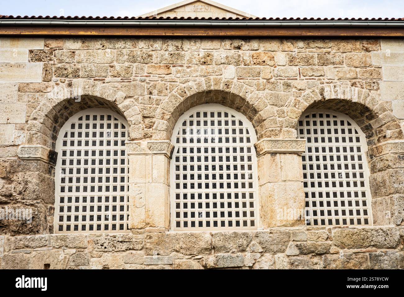 Historic stone building with three arched windows and grids Stock Photo ...