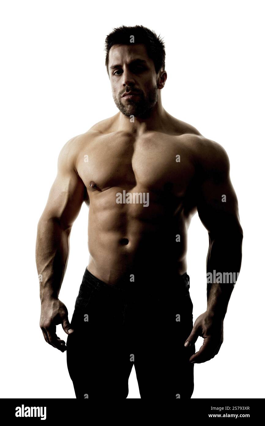 A handsome muscular sports man hard lit with deep shadows isolated on a ...