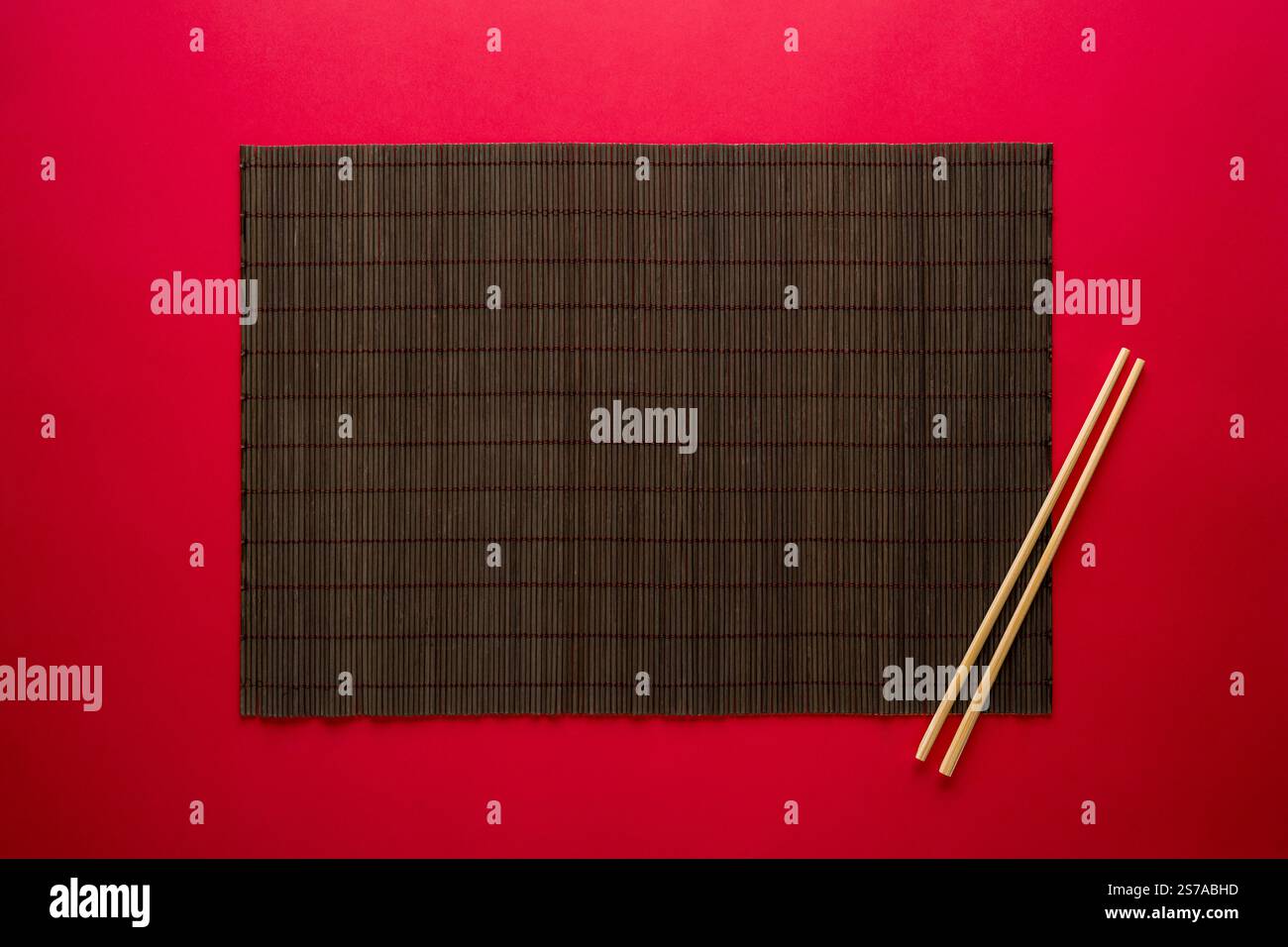 Sushi sticks and empty bamboo mat on red background Stock Photo - Alamy