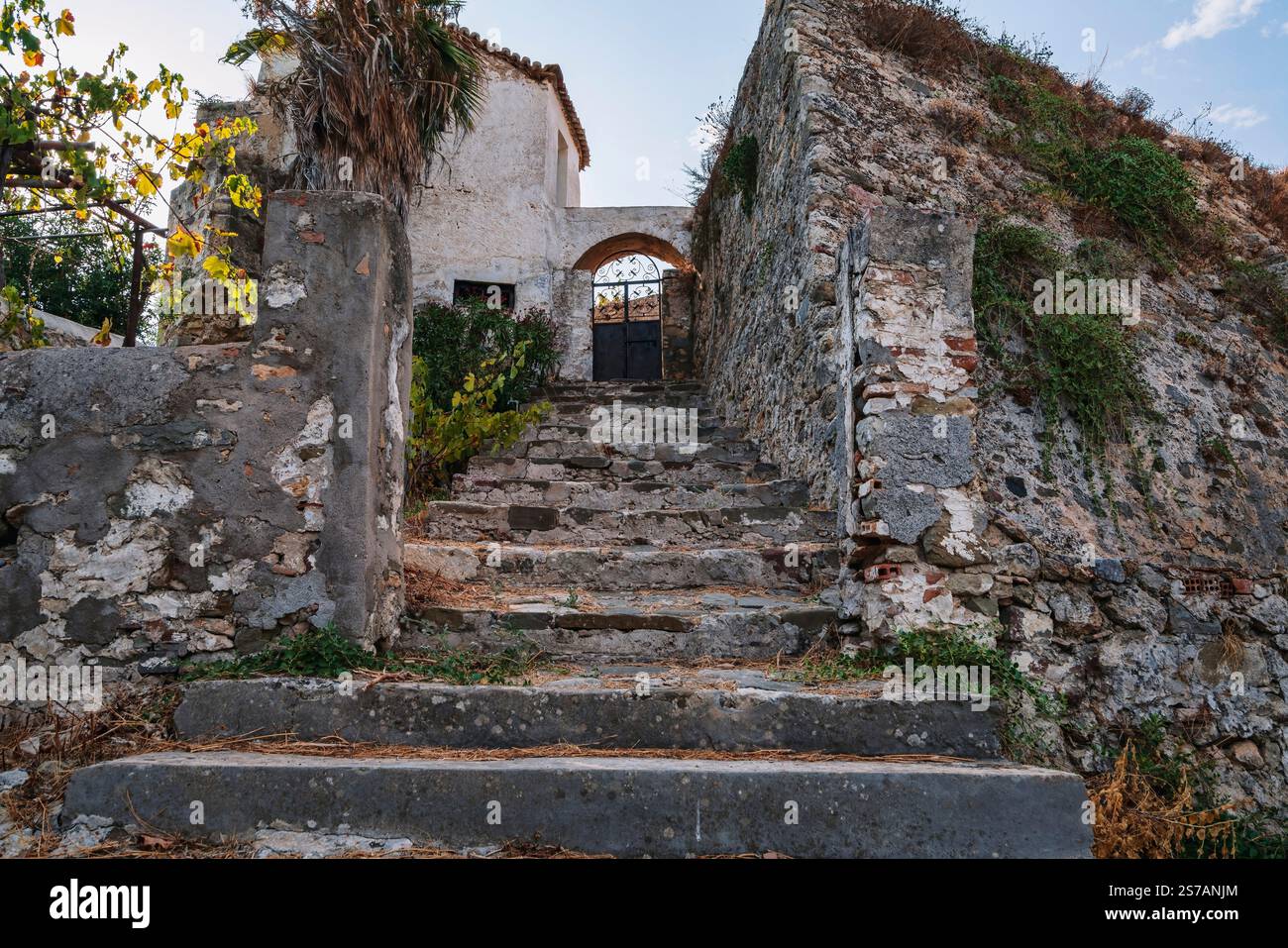An old stone stairway lined with rugged walls and vegetation, leading ...