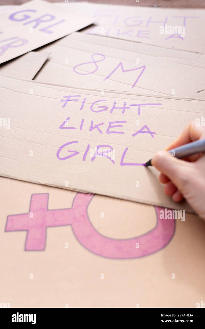 Close-up of activist's hand writing slogans on cardboard signs for ...