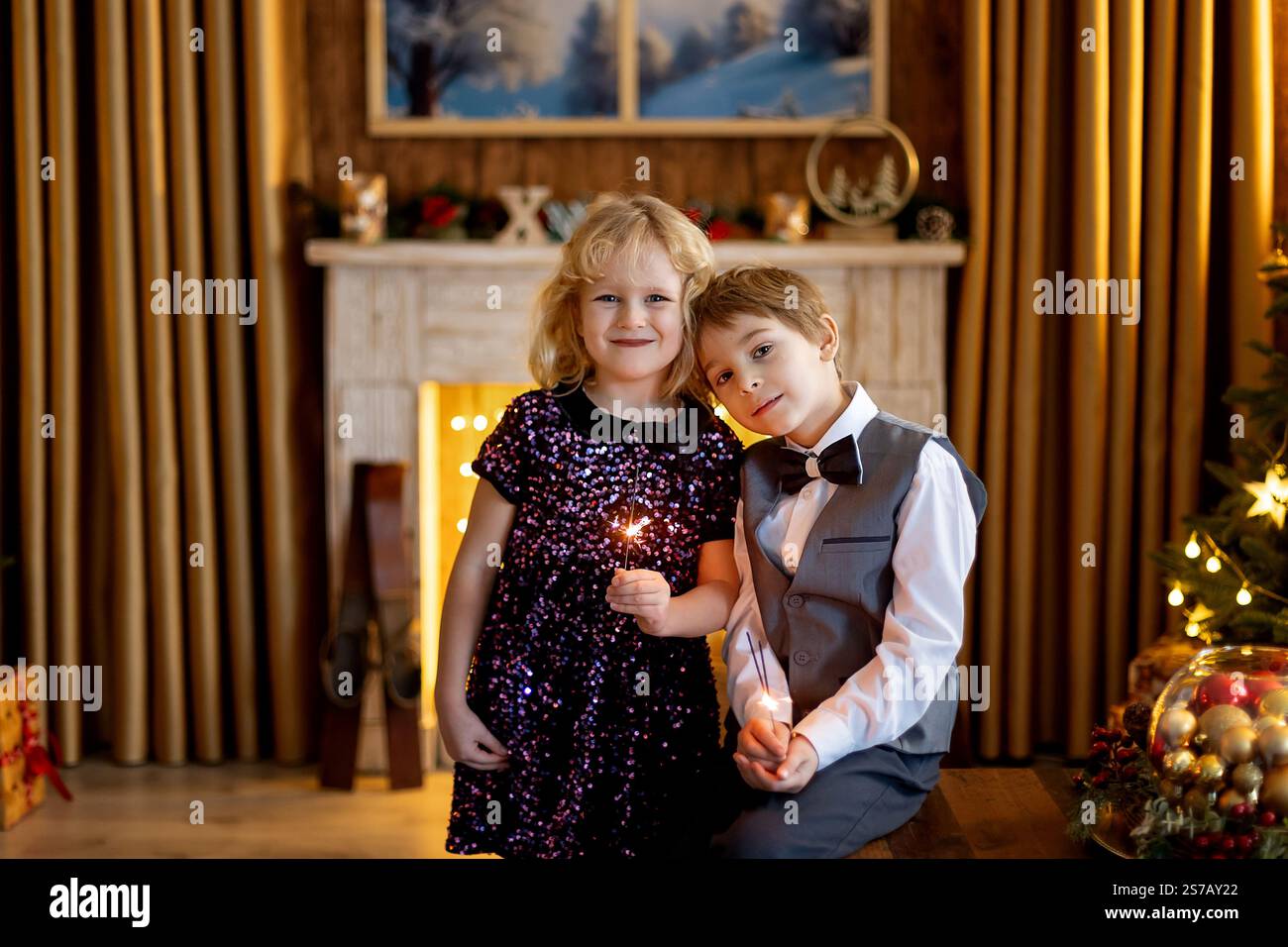 Brother and sister, children on christmas, holding sparklers in front ...