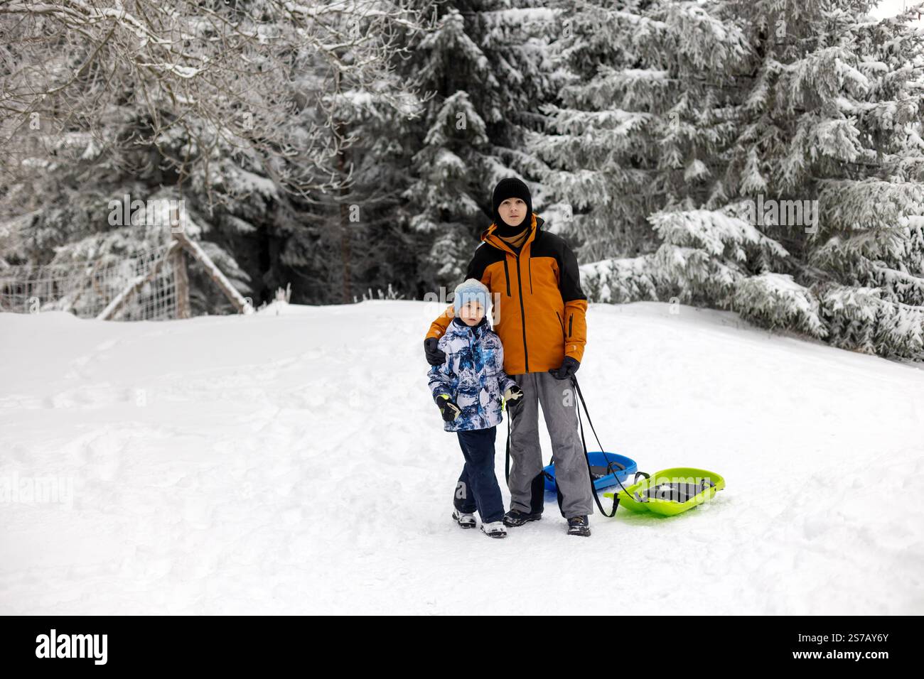 Sweet happy children, brothers, playing in deep snow in forest, frosted ...