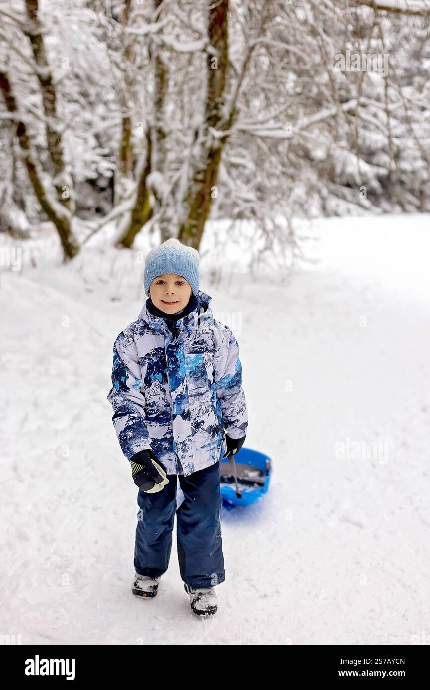 Sweet happy children, brothers, playing in deep snow in forest, frosted ...