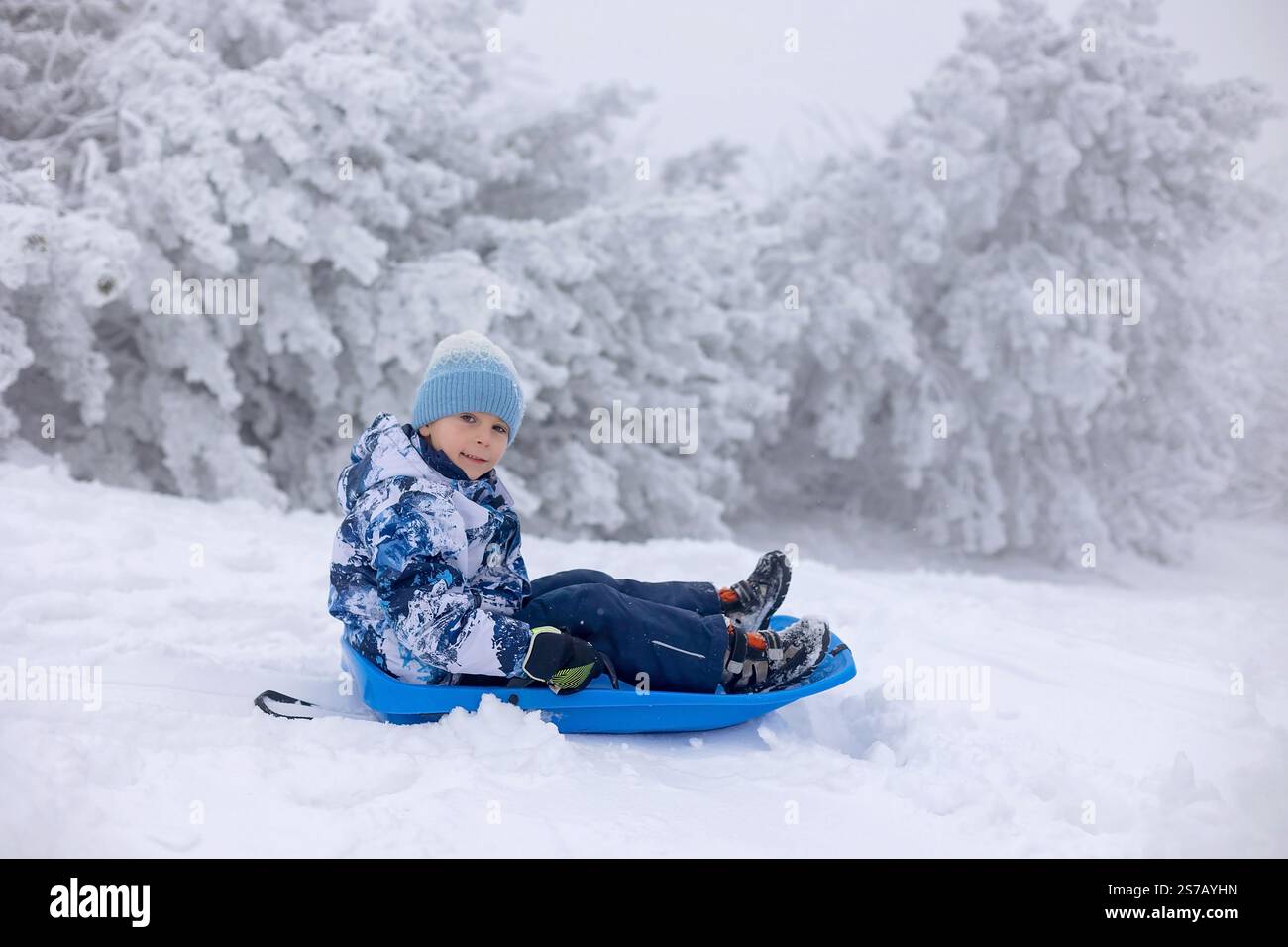 Sweet happy children, brothers, playing in deep snow in forest, frosted ...