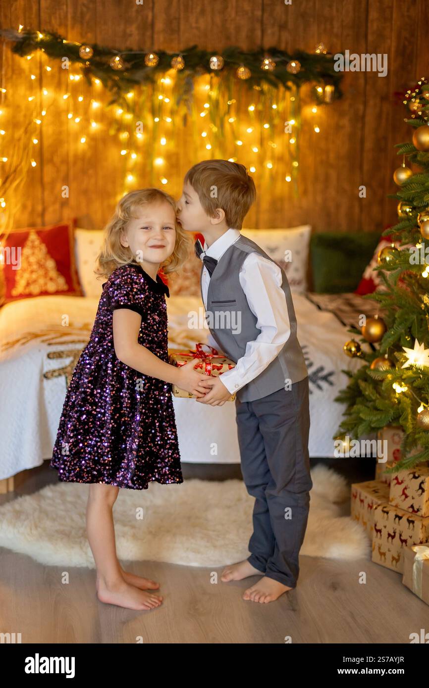 Sweet blond children, siblings, boy and girl, dressed smart casual in a ...