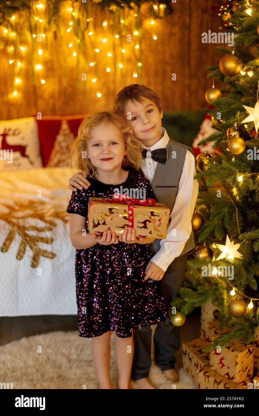 Sweet blond children, siblings, boy and girl, dressed smart casual in a ...
