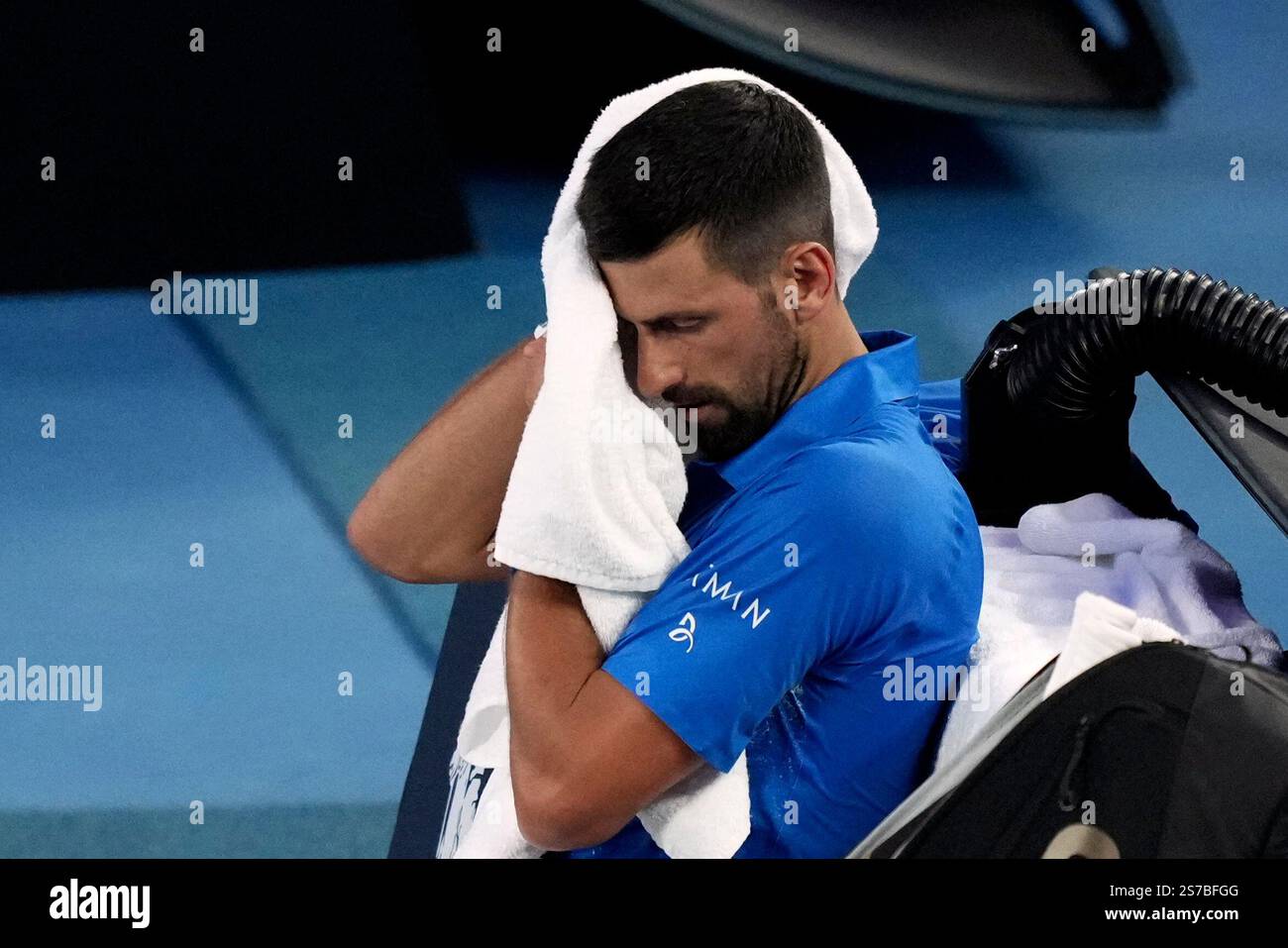 Novak Djokovic of Serbia wipes his face with a towel during a fourth ...