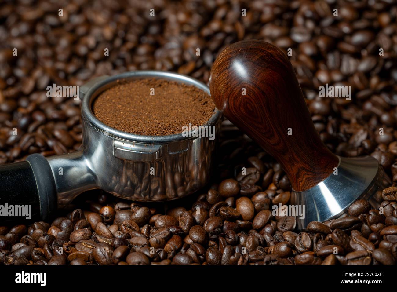 Close-up of a tamper and a coffee portafilter filled with freshly ...