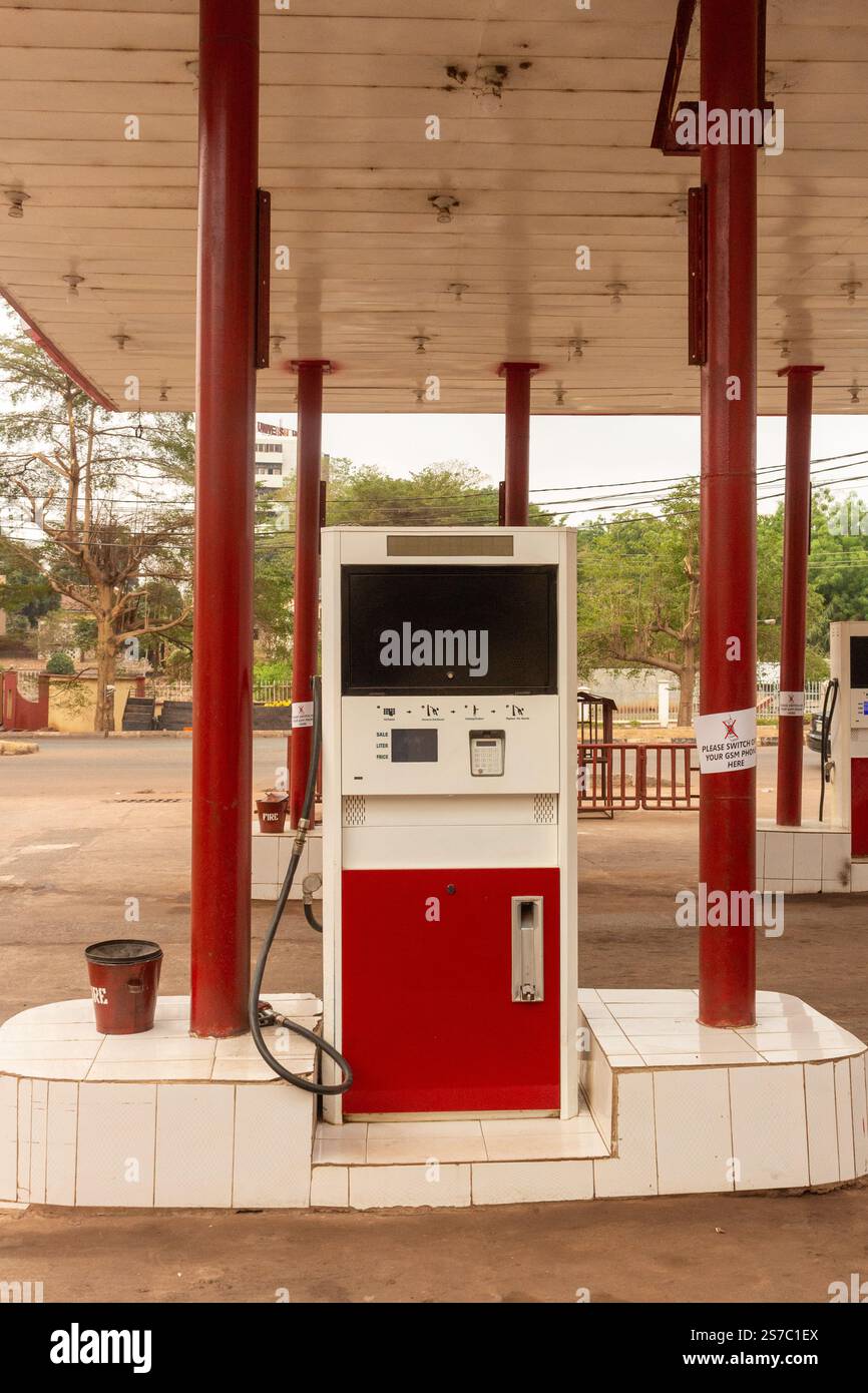 single gas pump between red metal pillars on a white tiled pedestal ...