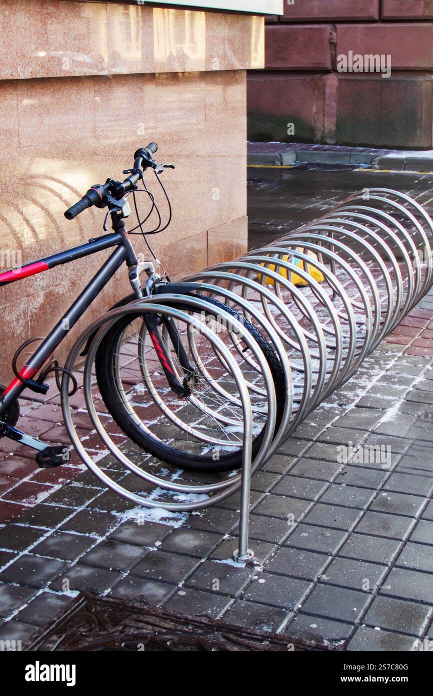 A bicycle is currently parked securely in a designated bicycle rack ...