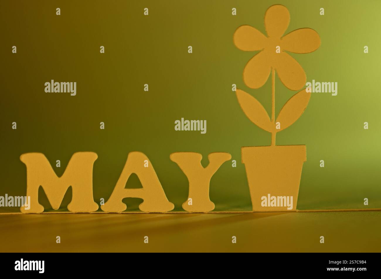 Yellow silhouette of paper cutout spelling the month of May Stock Photo ...